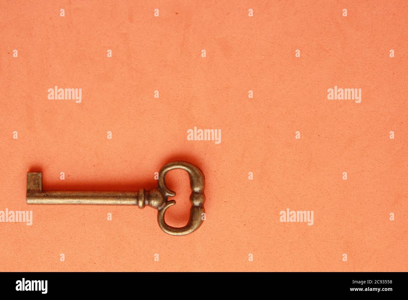 High angle closeup shot of a vintage closet key on an orange background ...