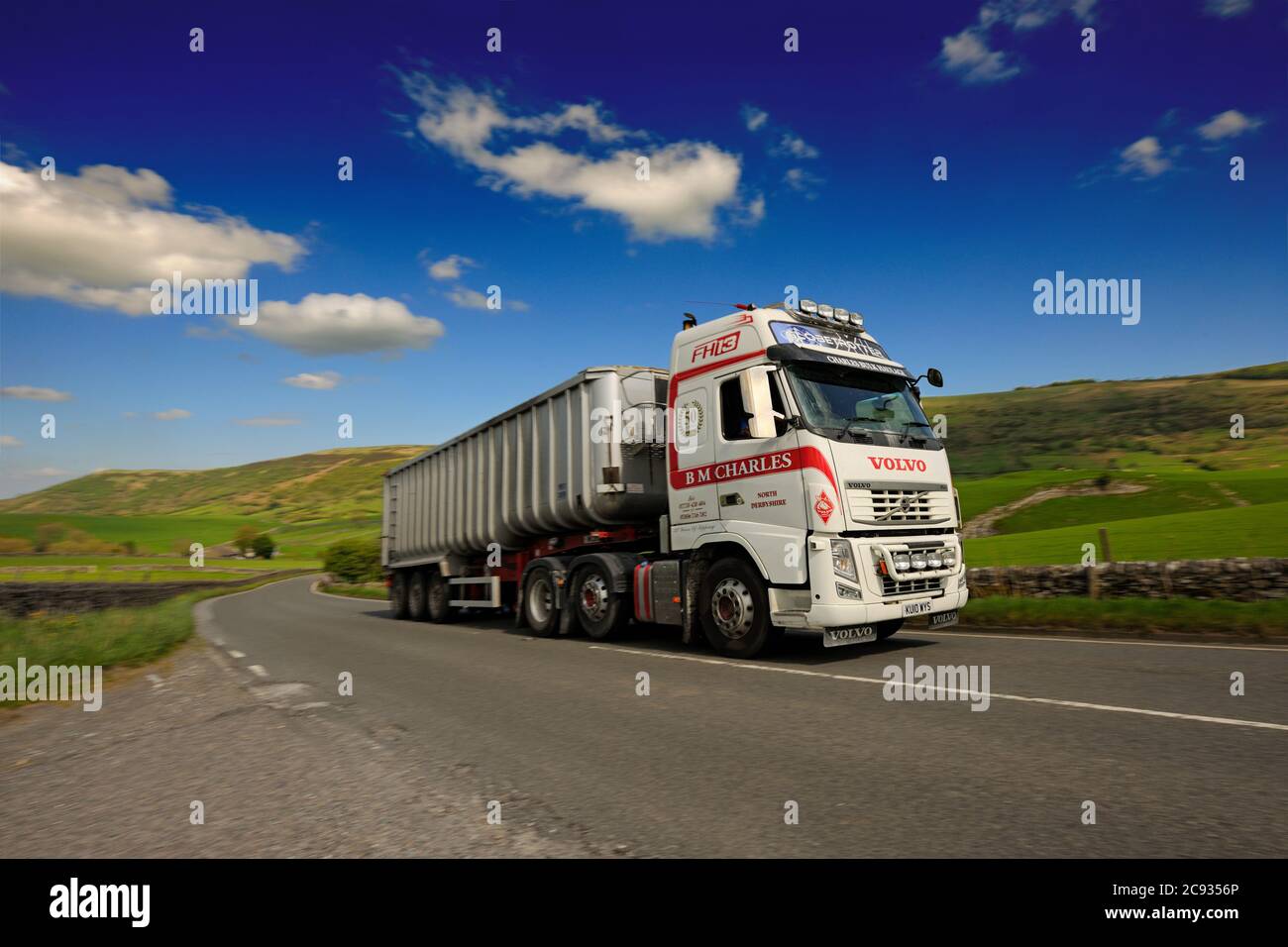Derbyshire-based B M Charles Volvo bulk tipper driving on an A-road in ...