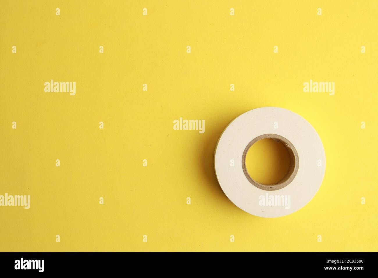Top view of a tape roll under the lights on a yellow surface Stock ...