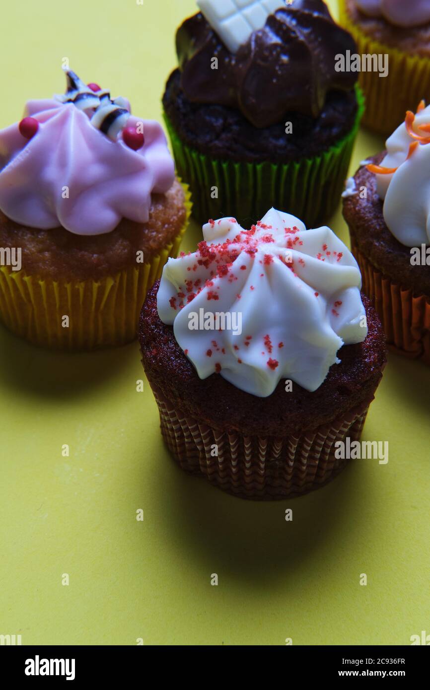 Vertical closeup shot of small cupcakes with colorful creams Stock ...