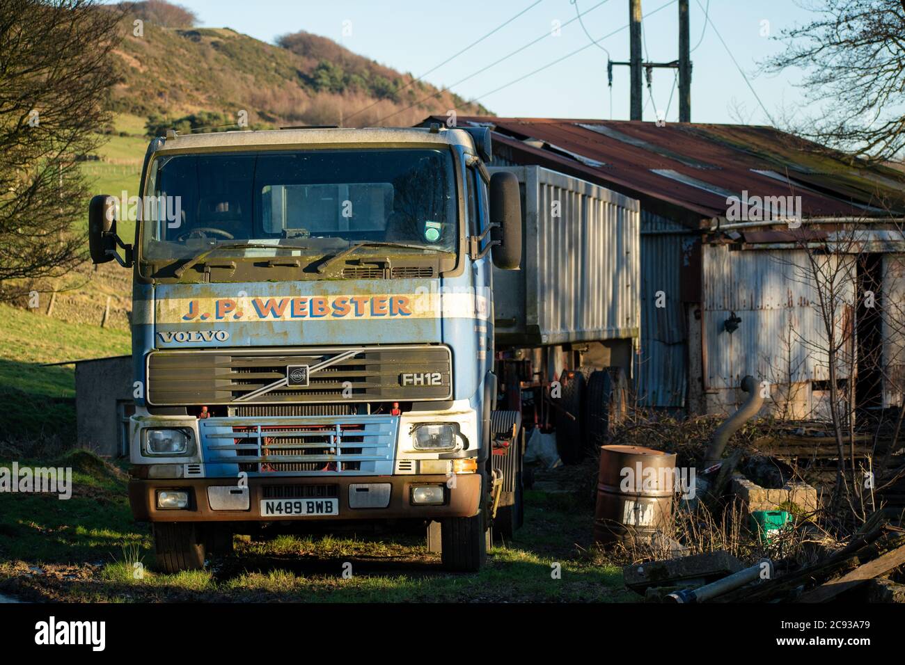 Disused Volvo FH12 truck and bulk tipper trailer parked on a hill farm ...