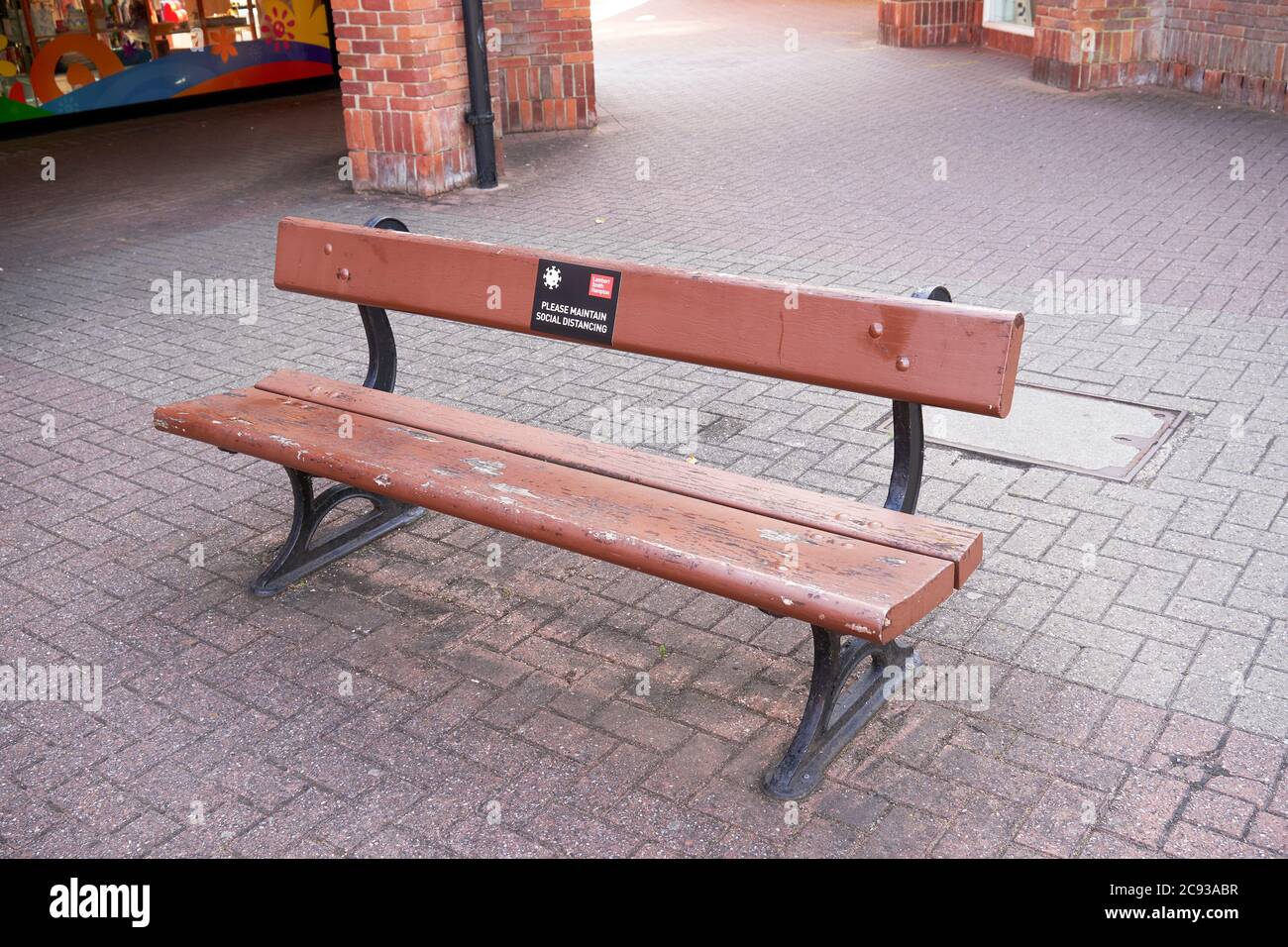 Empty public bench seat with social distancing sticker Stock Photo - Alamy