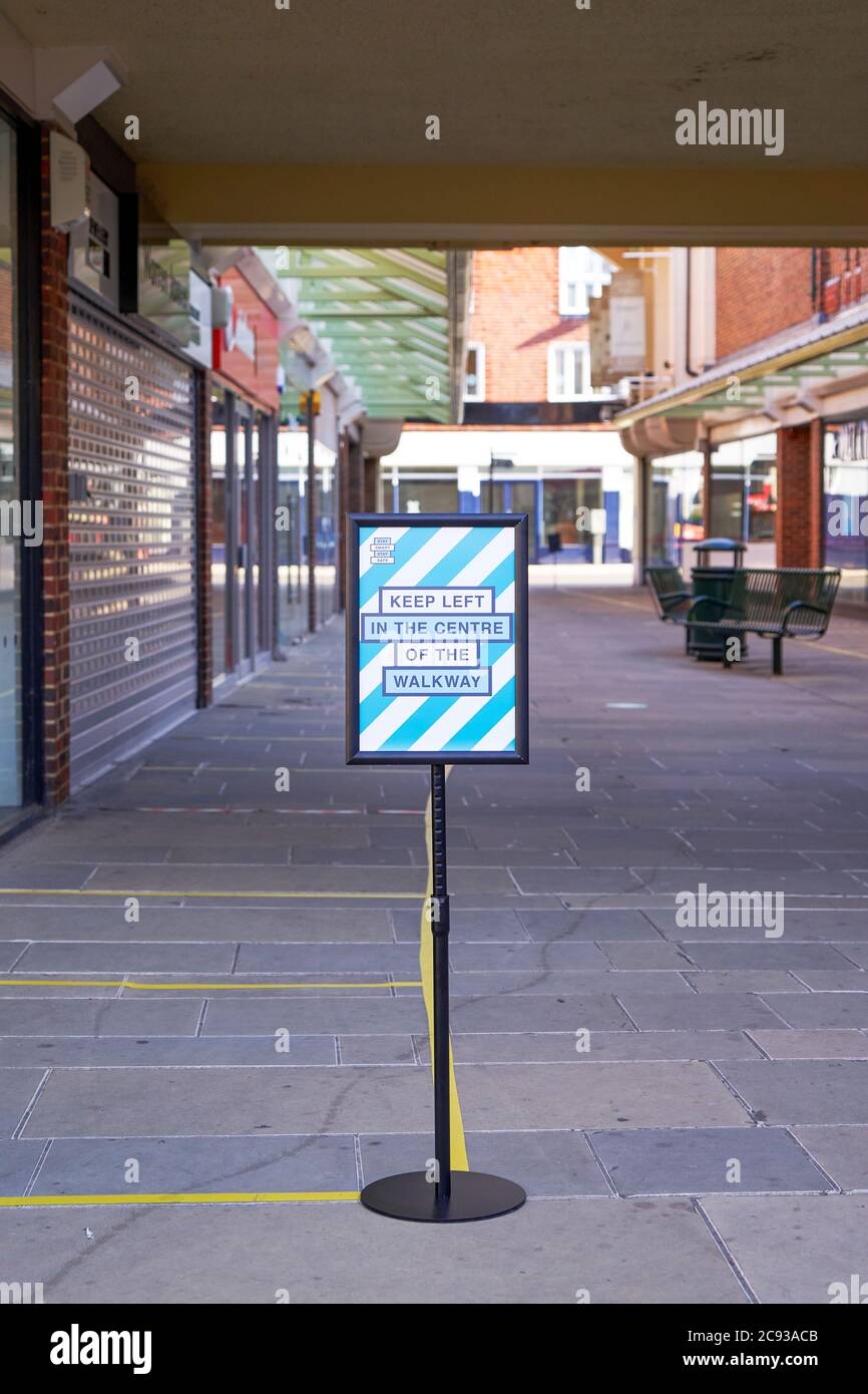 Sign instructing pedestrians to walk to the left in shopping centre to ...