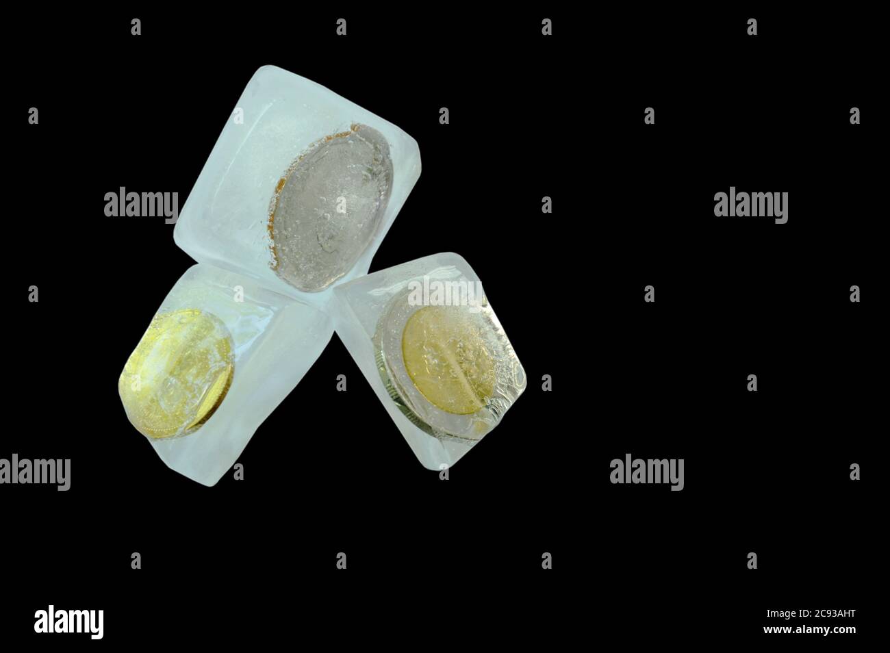 coin freezing in ice cube on black background Stock Photo - Alamy
