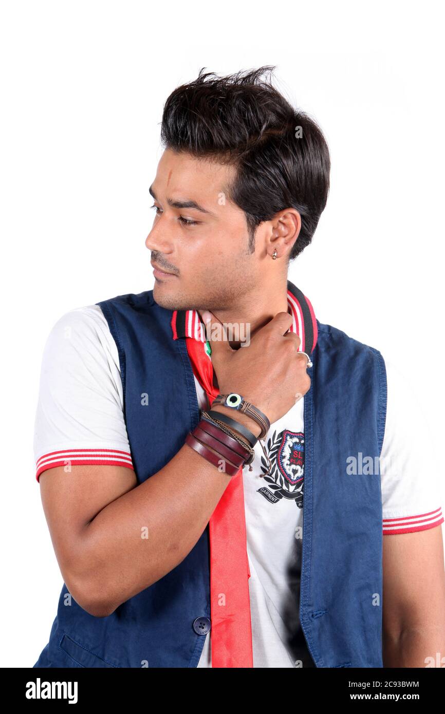 A handsome young Indian guy lost in his thoughts, on white studio ...