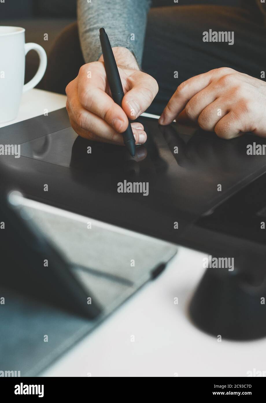 Graphic designer using electronic drawing tablet at home Stock Photo ...