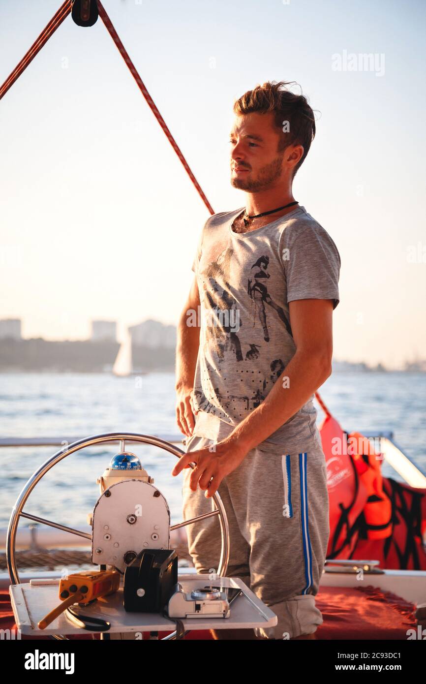 Young handsome man, captain driving yacht in sea at sunny day Stock ...