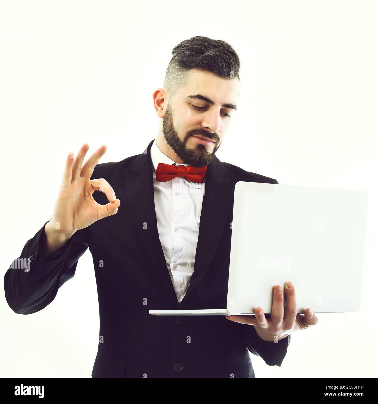 Businessman or TV announcer shows OK sign and holds white laptop ...