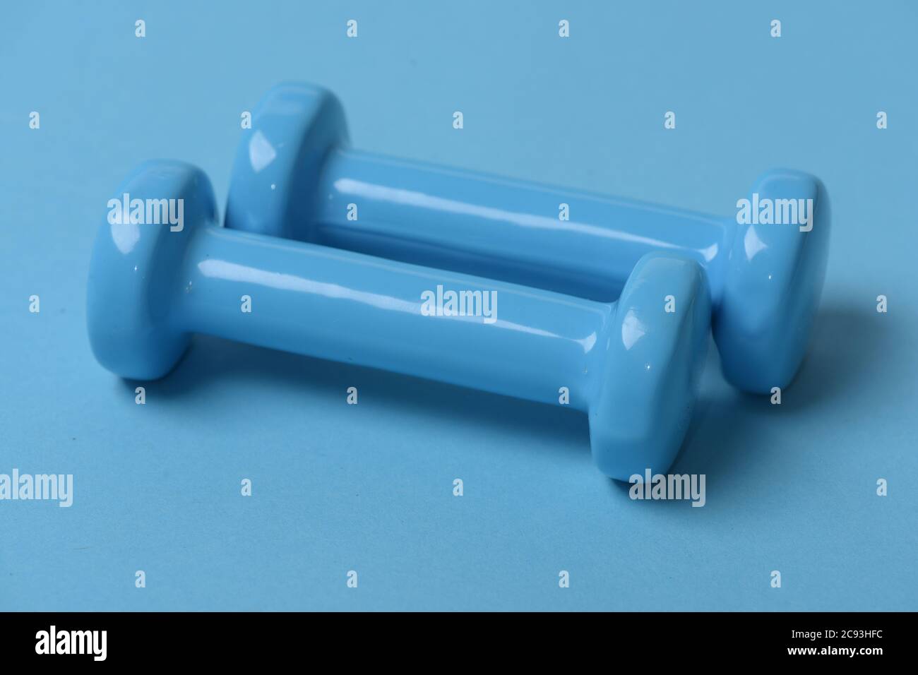 Dumbbells made of blue plastic on blue background. Healthy lifestyle ...