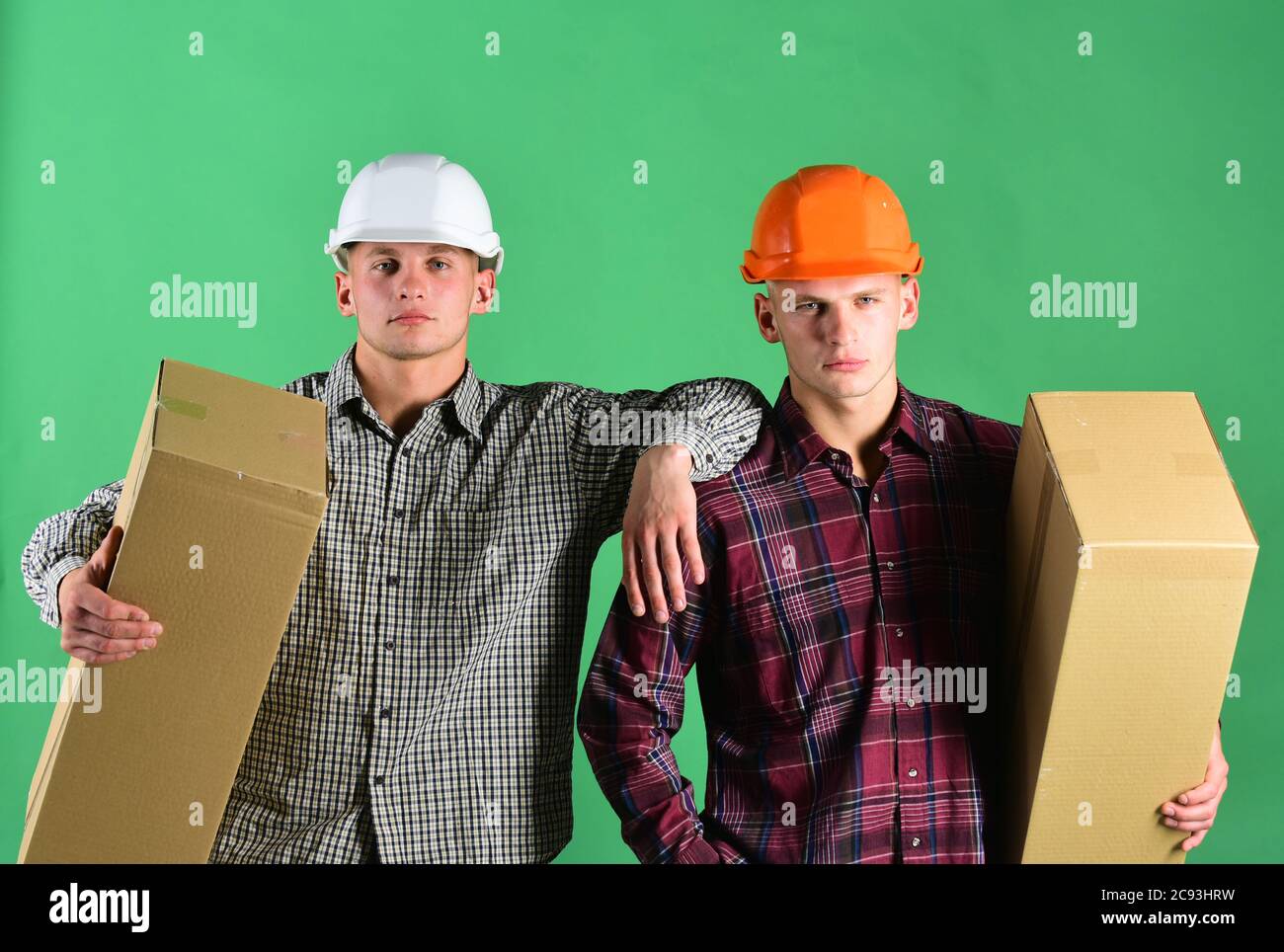 Men with confident faces hold cardboard boxes isolated on green ...