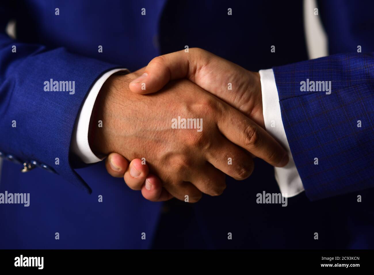 Male hands shaking tight, close up. Handshake on light grey background ...