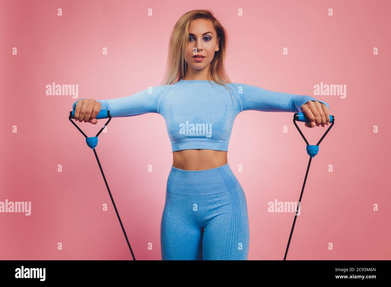 Happy fitness woman in sportwear celebrating his success over pink ...
