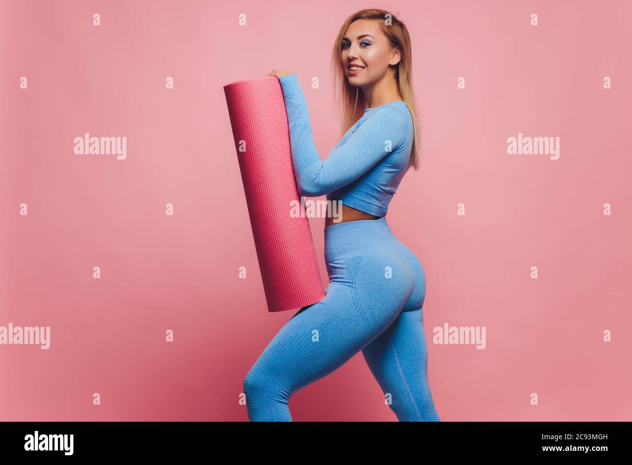 Happy fitness woman in sportwear celebrating his success over pink ...