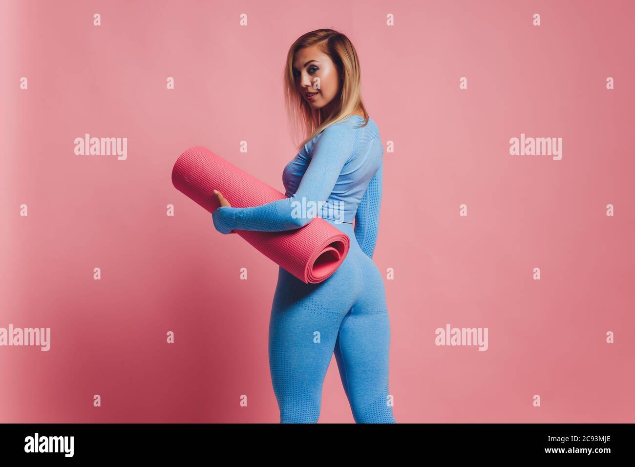 Happy fitness woman in sportwear celebrating his success over pink ...