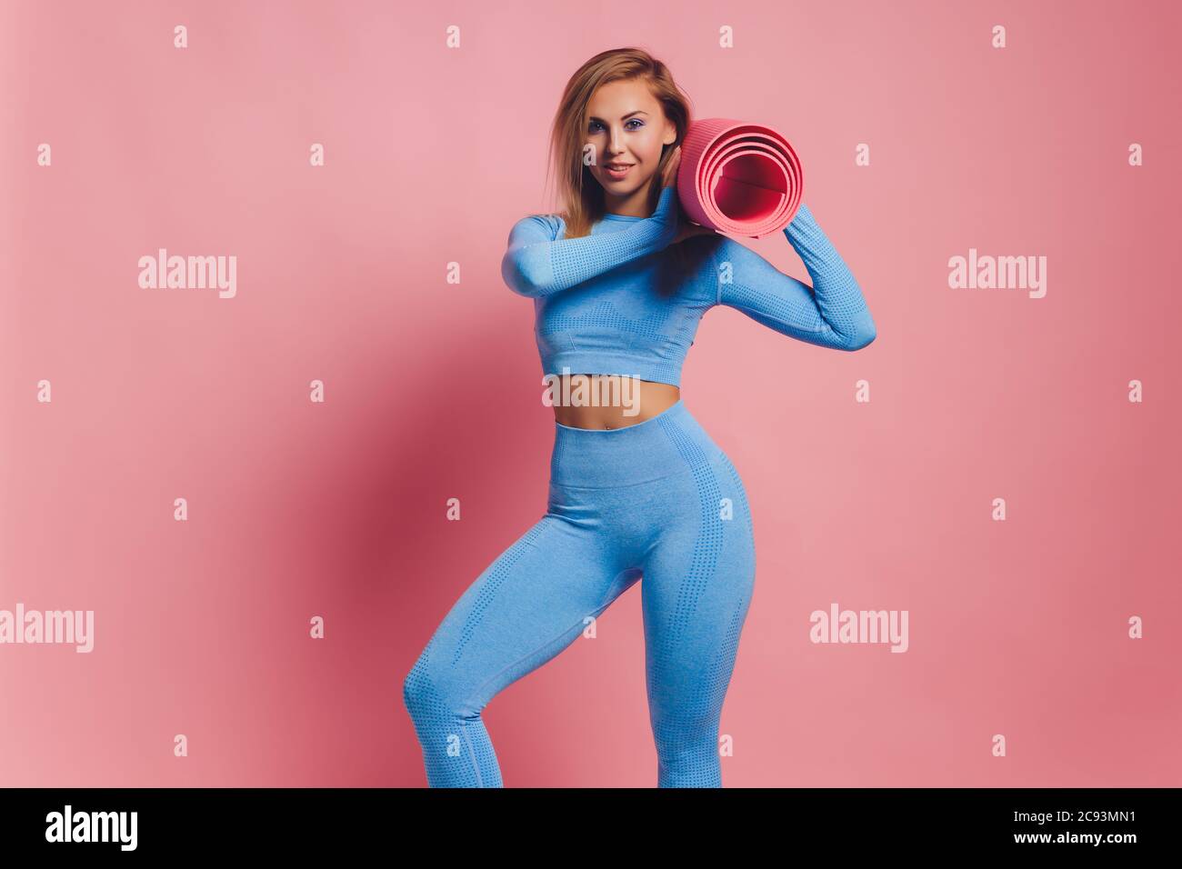 Happy fitness woman in sportwear celebrating his success over pink ...