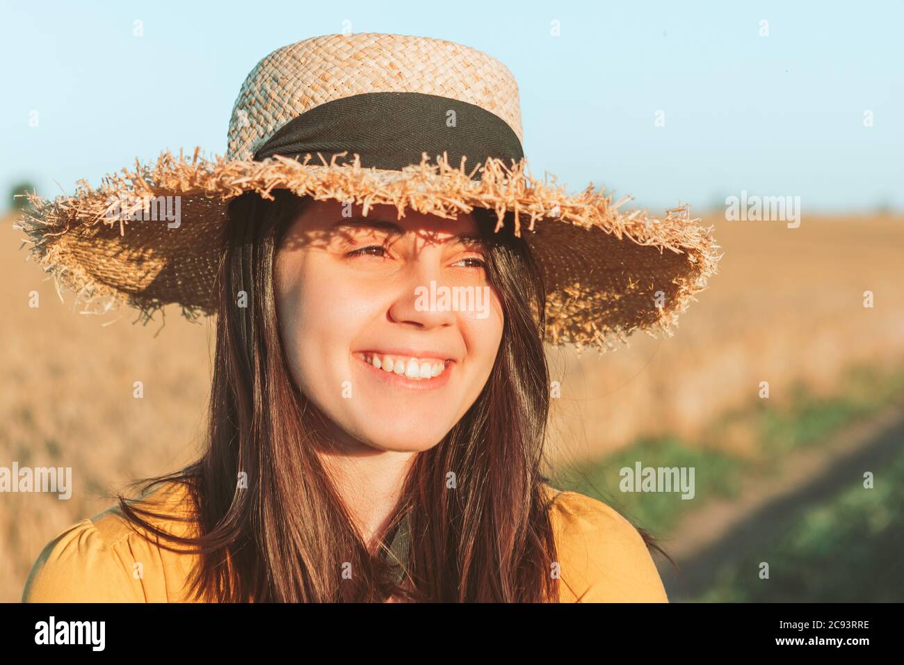 portrait of beautiful woman in straw hat on sunset in field Stock Photo ...