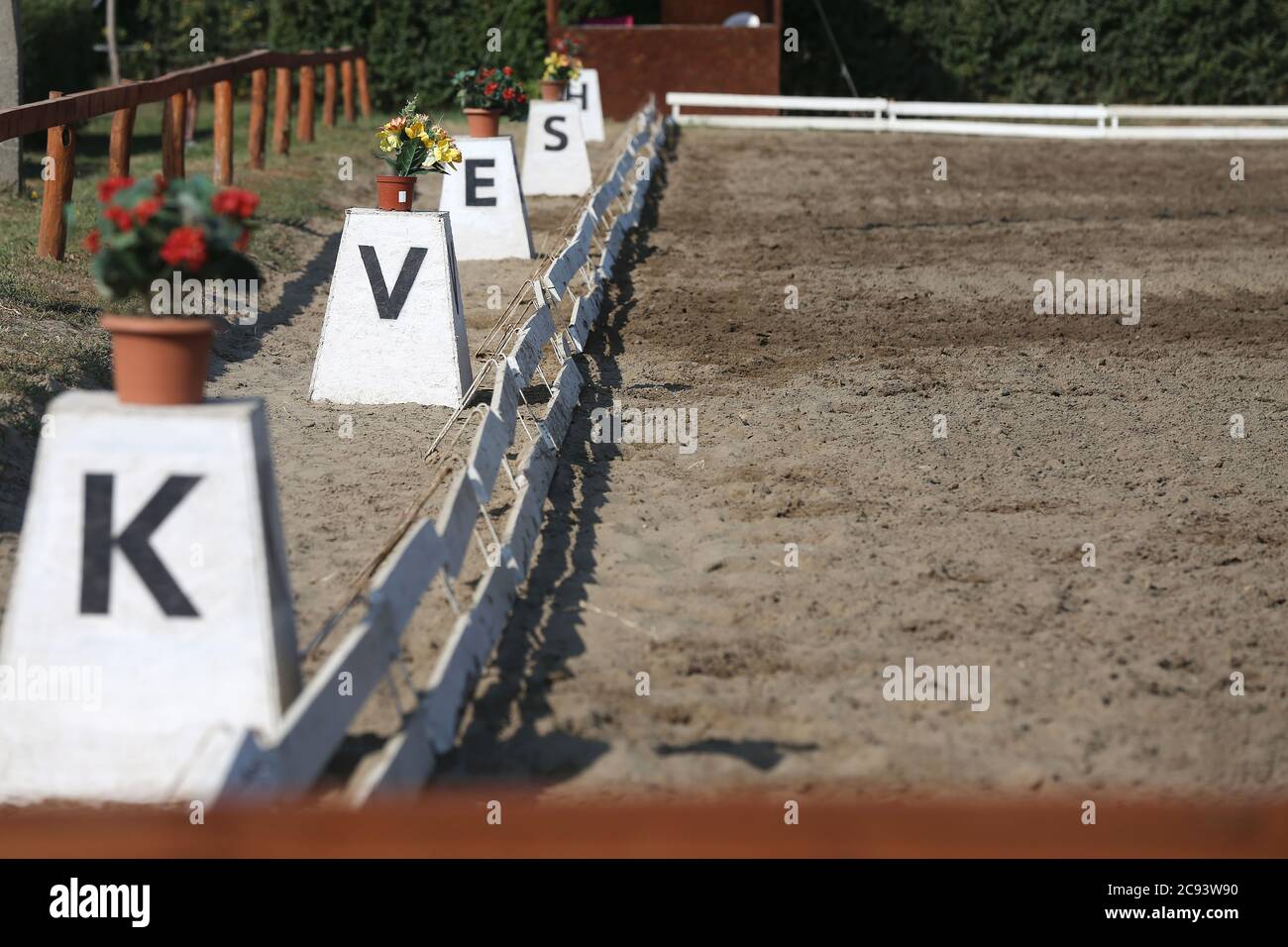 Sand covered equestrian horse arena close up white railing borders ...