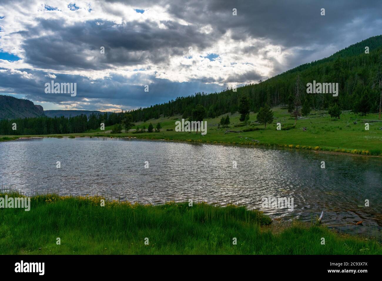 Sun rays shine over geothermal pool in Yellowstone National Park Stock ...