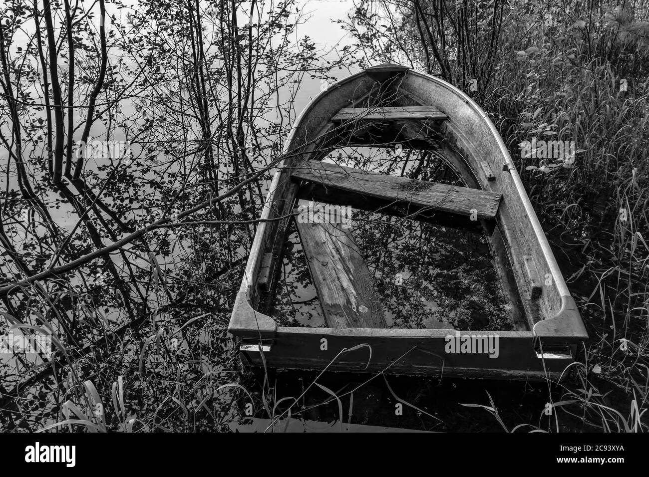 Small fishing boat abandoned and filled with water at edge of Imp Lake ...