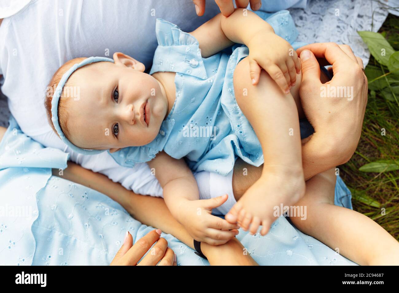 Portrait of little baby girl in caring parents arms Stock Photo - Alamy