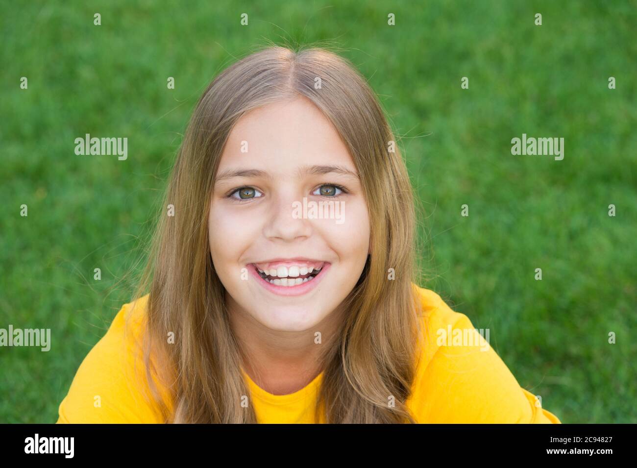 Happy smiling little girl relaxing green grass, sincere emotions ...