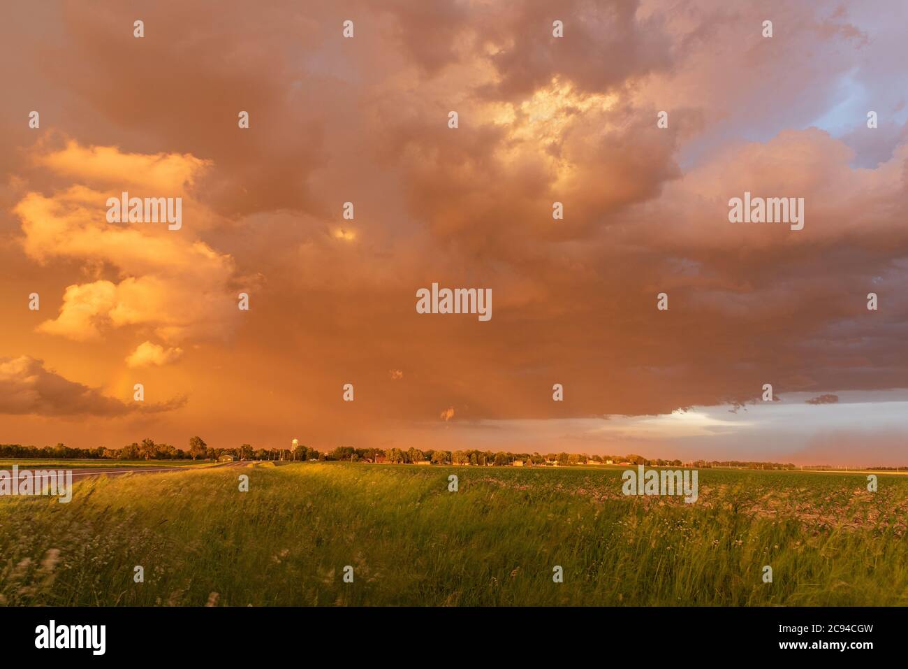 A large dust storm blows across a field and small town at sunset ...