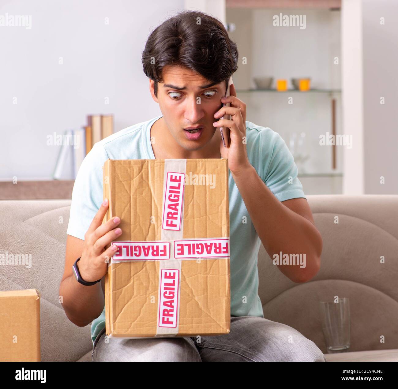 The man opening fragile parcel ordered from internet Stock Photo - Alamy