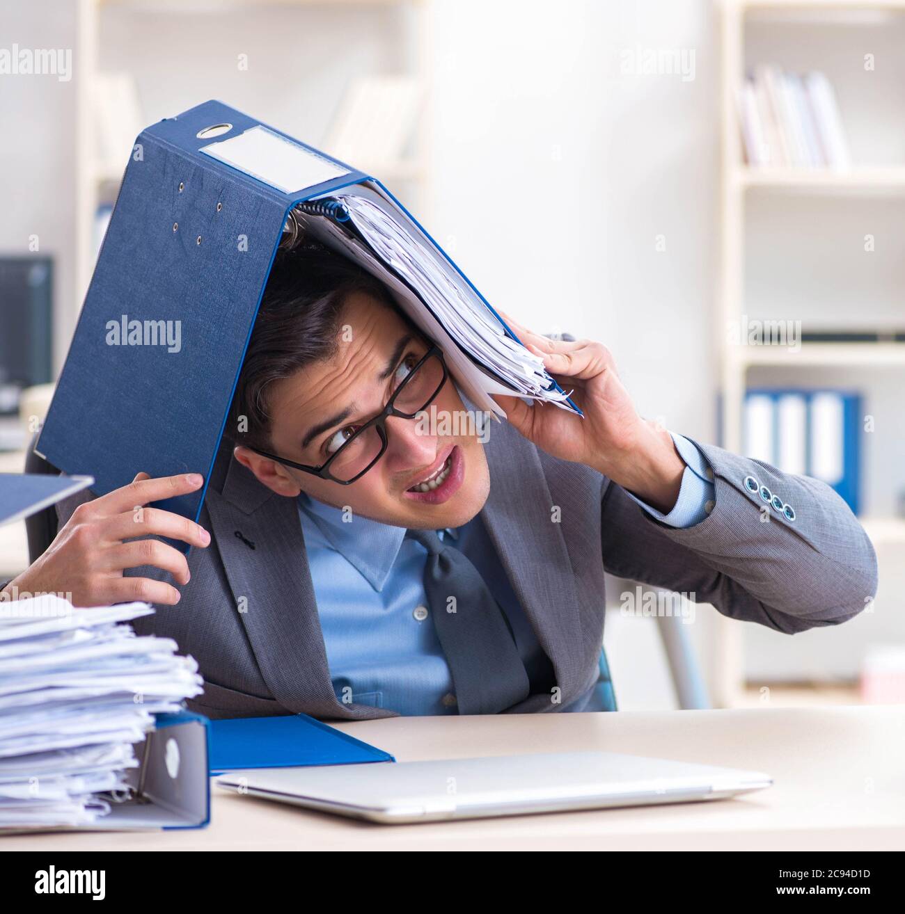 The overloaded with work employee under paperwork burden Stock Photo ...