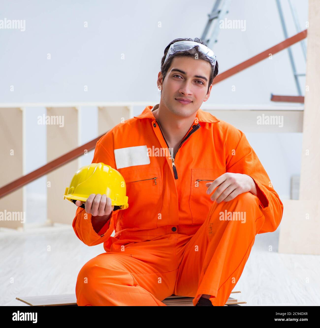 The carpenter wearing yellow hardhat in contractor workshop Stock Photo ...
