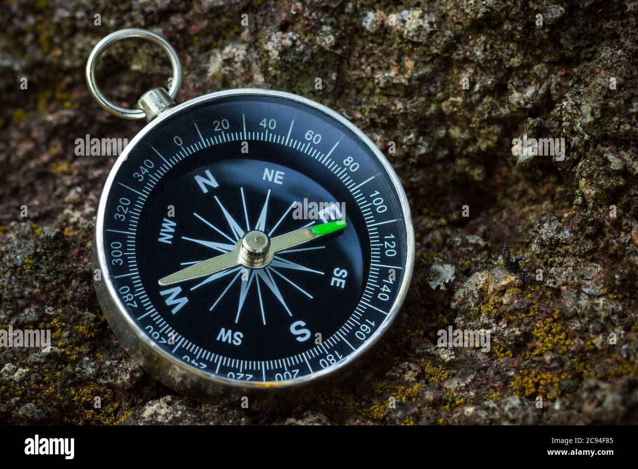 Compass placed on the rock in forest. Closeup and copy space. Concept ...