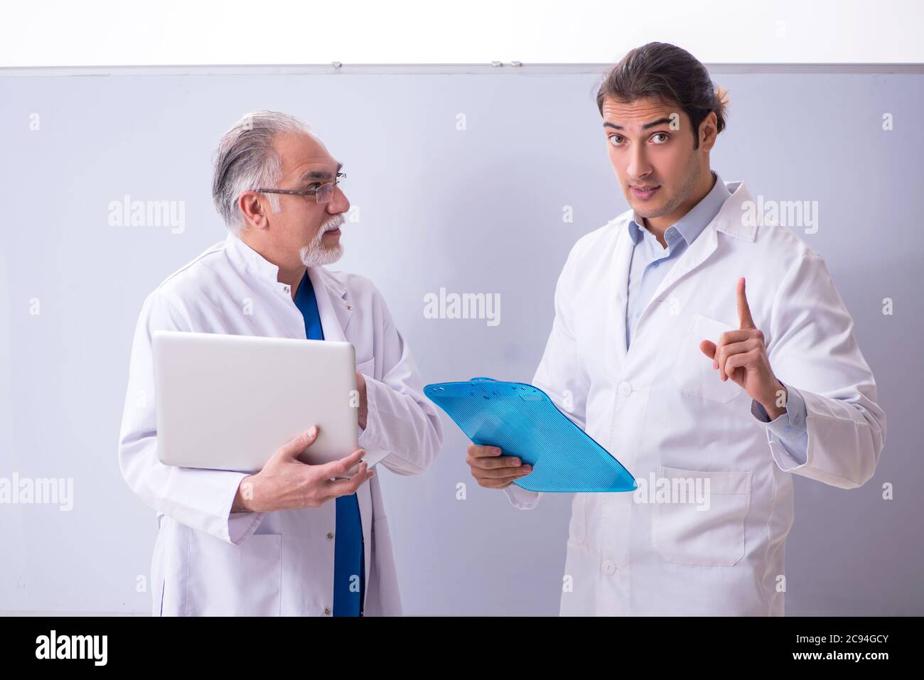 Experienced doctor teaching young assistant using computer Stock Photo ...
