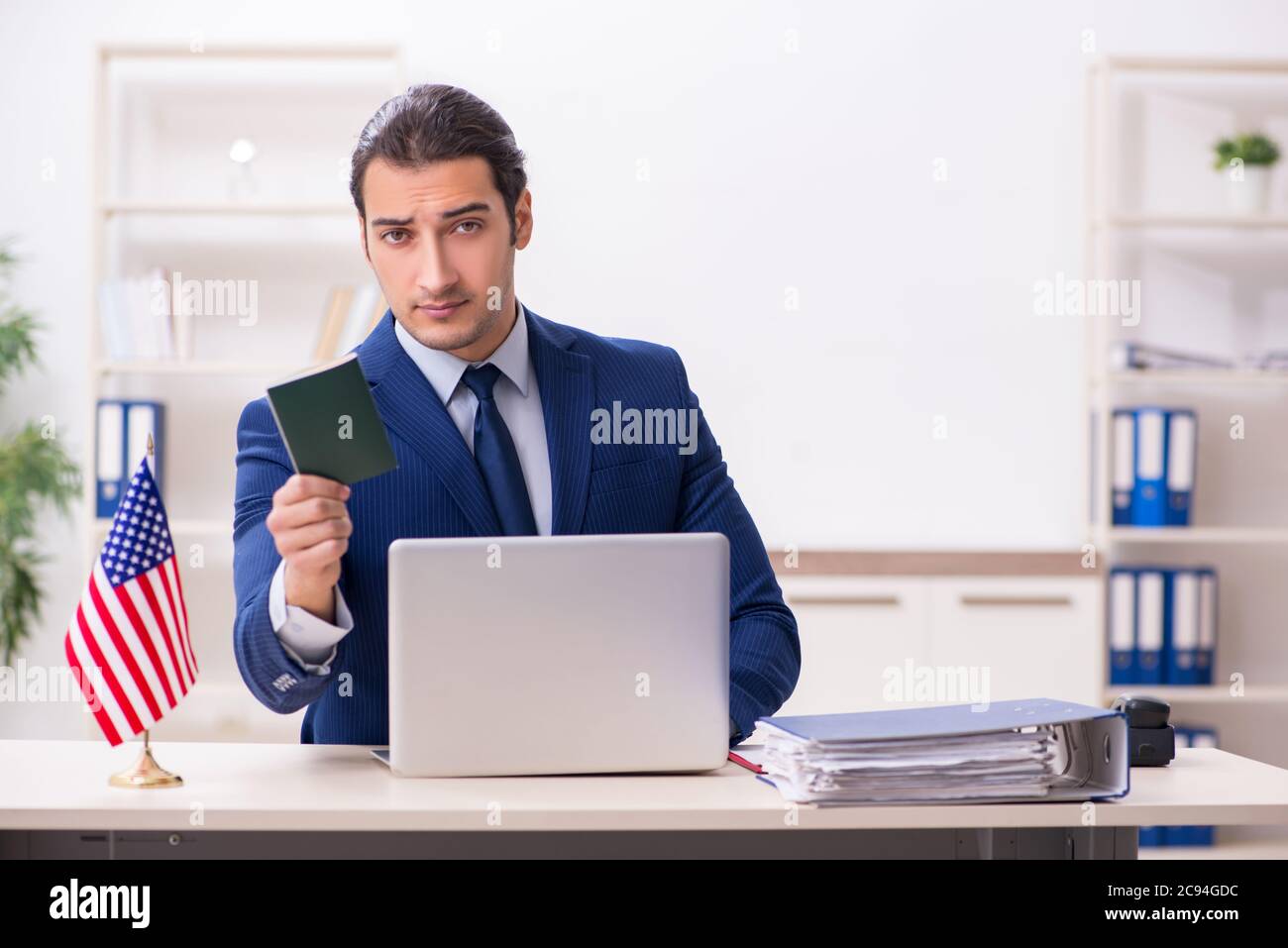 Young man checking passport at the USA embassy Stock Photo - Alamy