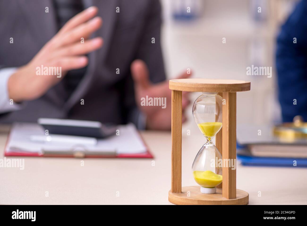 Two businessmen in the time management concept Stock Photo - Alamy