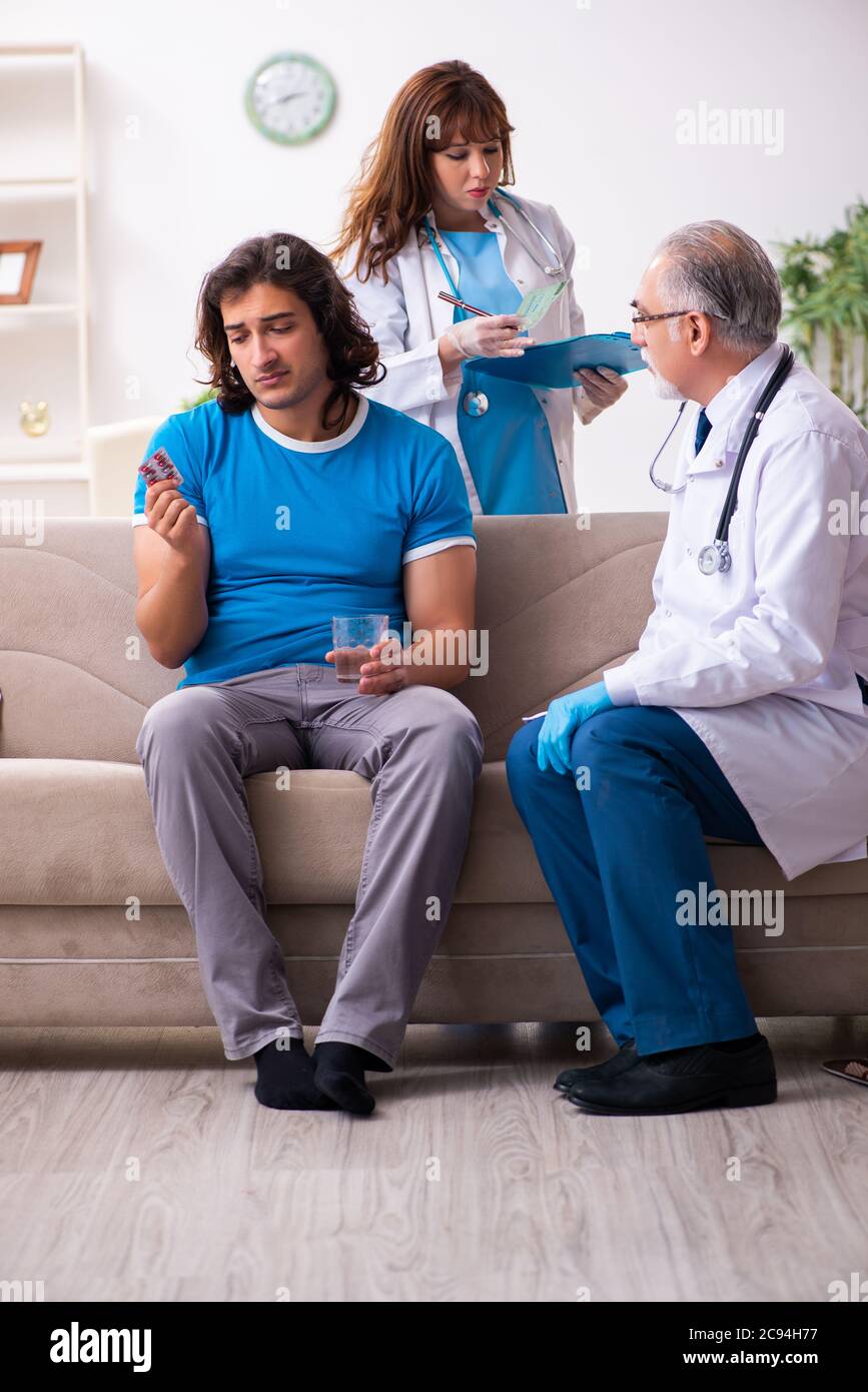 Two doctors visiting sick man at home Stock Photo - Alamy