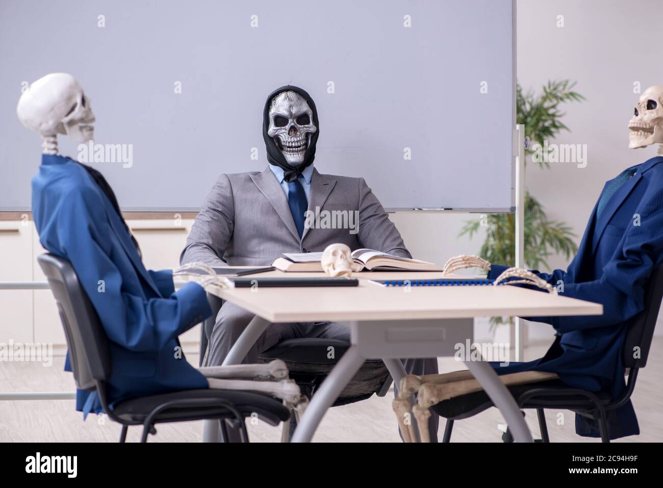 Funny business meeting with the devil and skeletons Stock Photo - Alamy