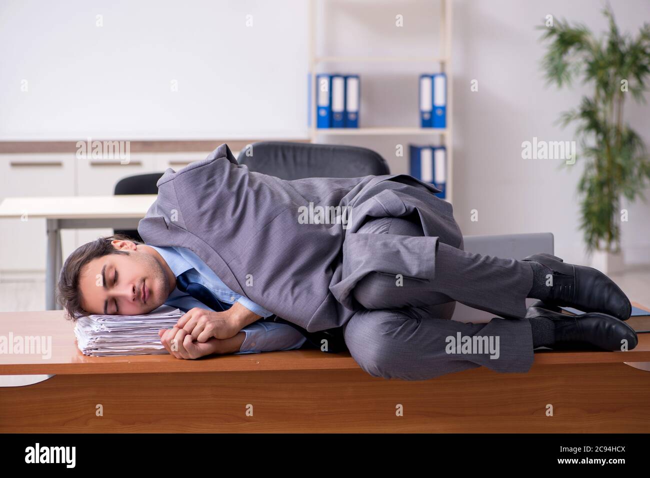 Young employee sleeping in the office Stock Photo - Alamy
