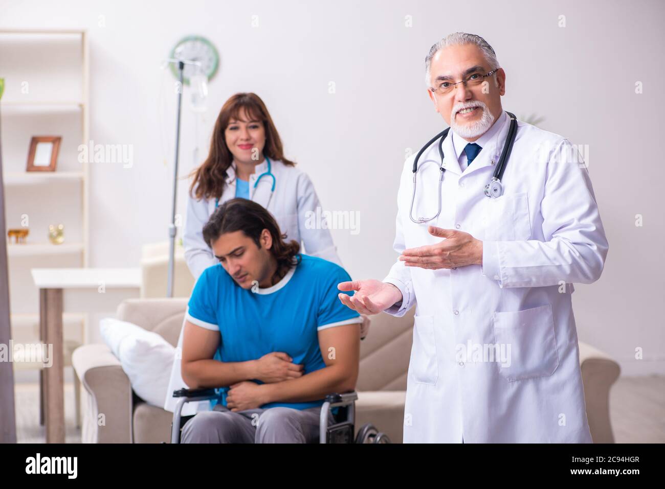 Two doctors visiting sick man at home Stock Photo - Alamy