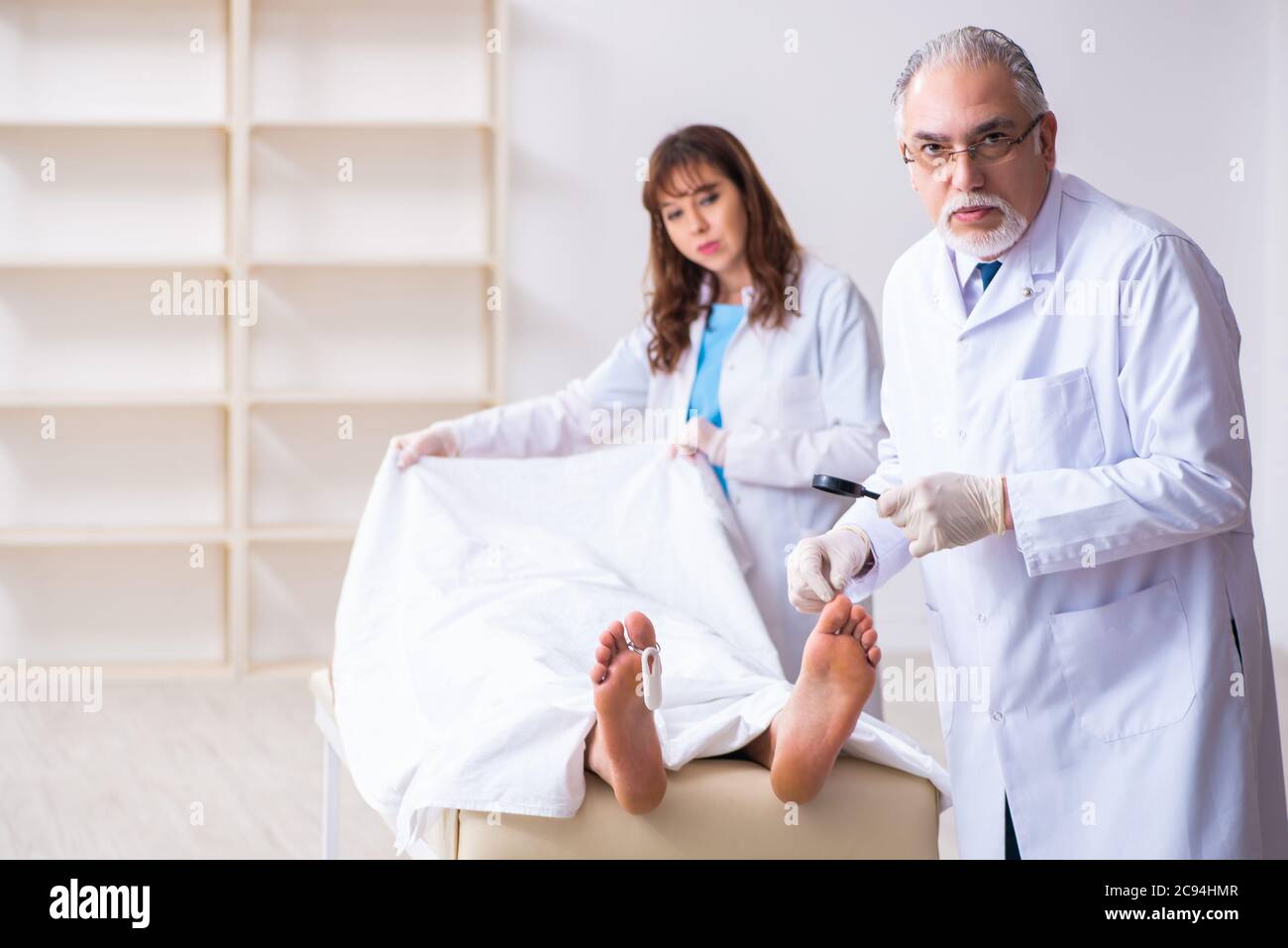 Police coroner examining dead body corpse in the morgue Stock Photo - Alamy
