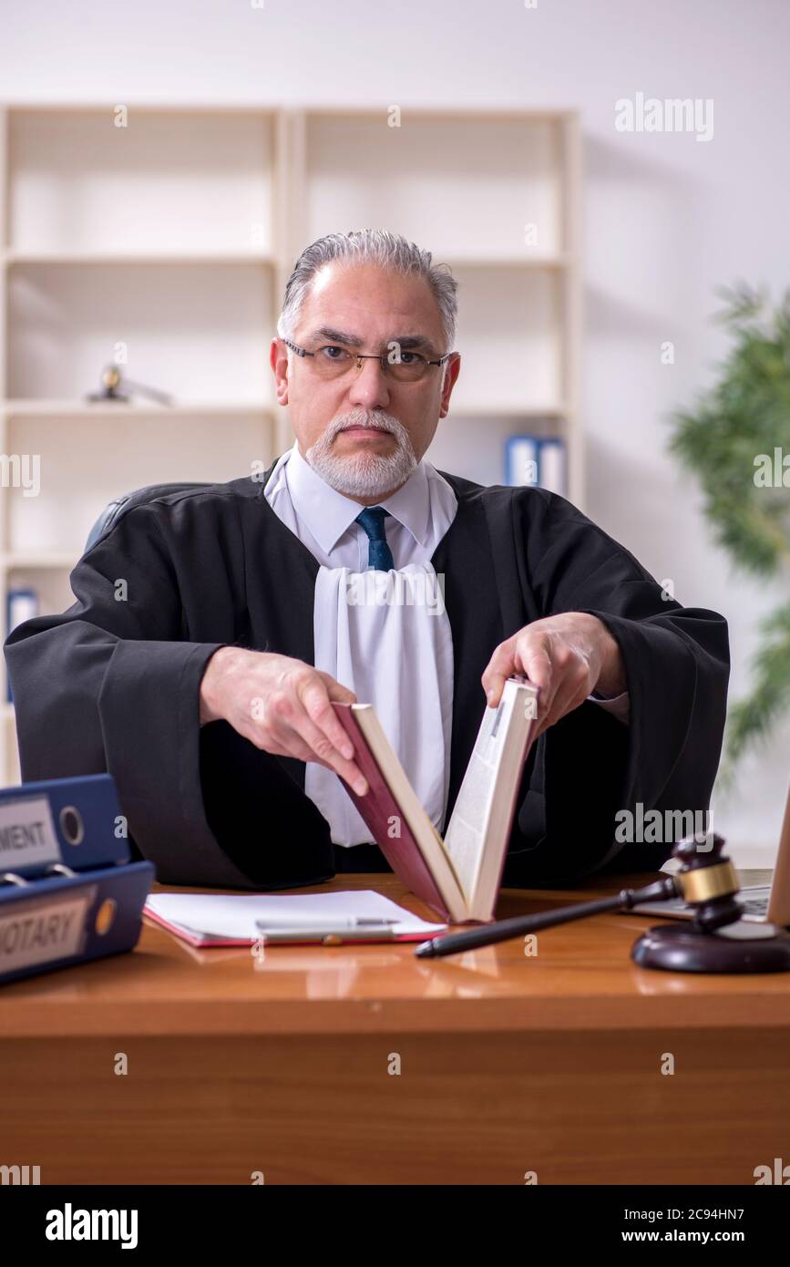 Old male judge working in the courthouse Stock Photo - Alamy