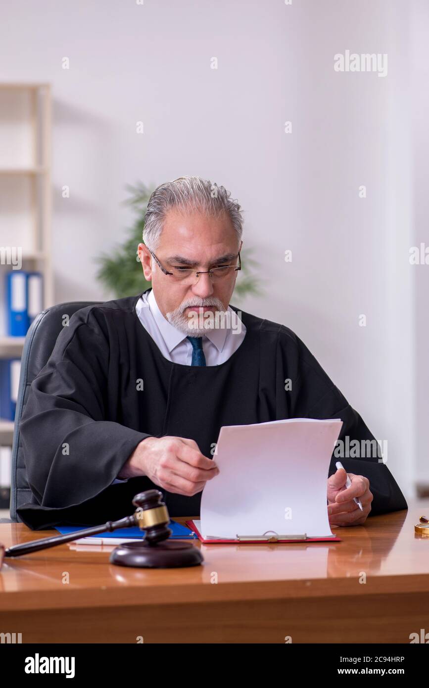 Old male judge working in the courthouse Stock Photo - Alamy