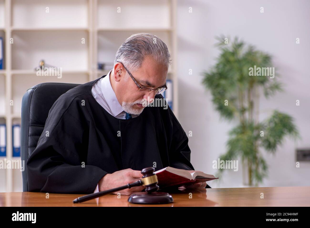 Old male judge working in the courthouse Stock Photo - Alamy