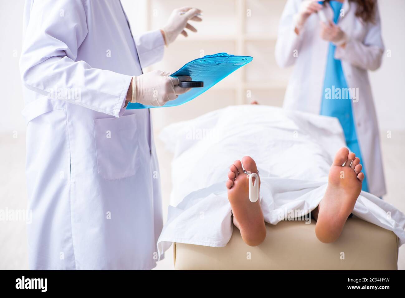 Police coroner examining dead body corpse in the morgue Stock Photo - Alamy