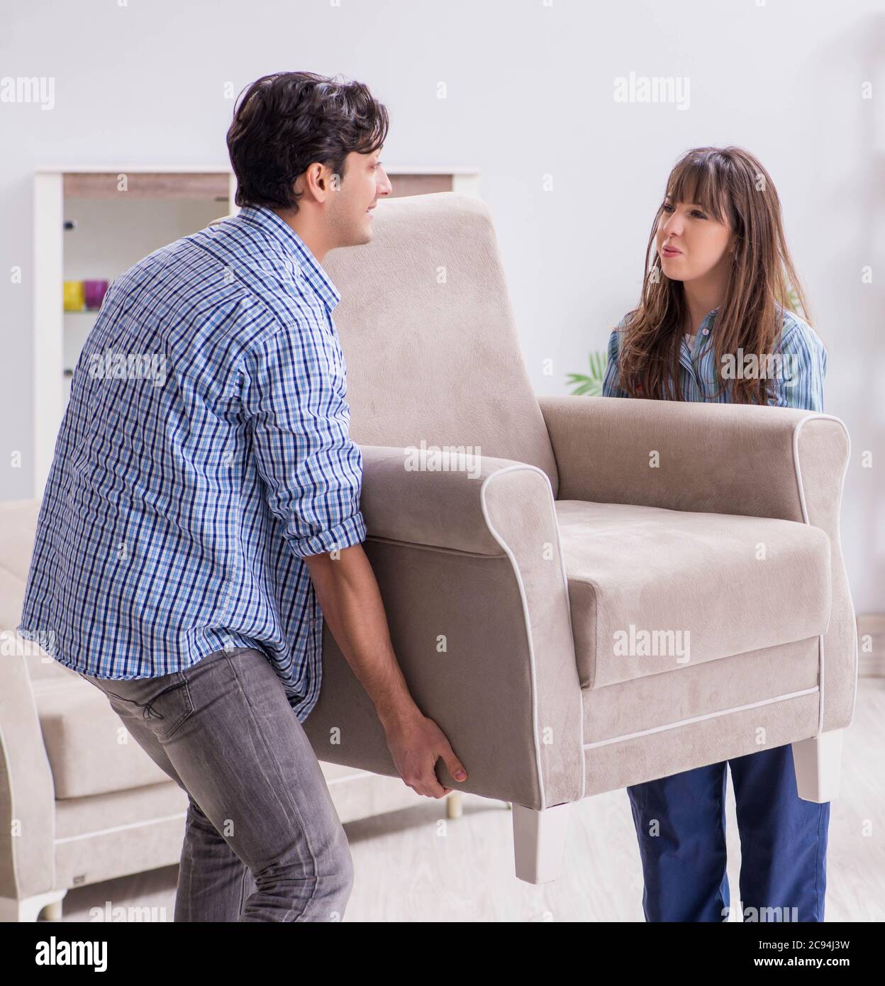 The man moving armchair in the living room Stock Photo - Alamy