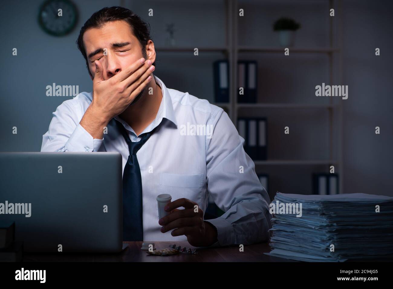 Young employee working in the office night time Stock Photo - Alamy