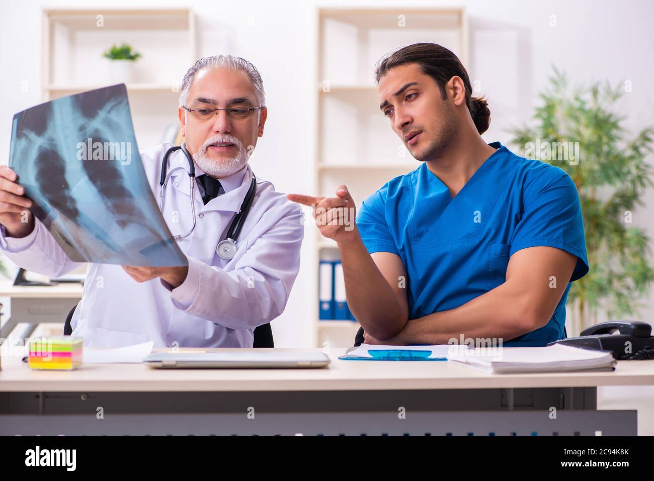 Two male doctors working in the modern clinic Stock Photo - Alamy