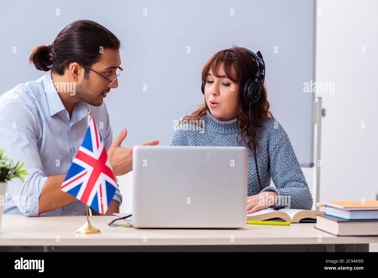Young student and male english teacher in the classroom Stock Photo - Alamy