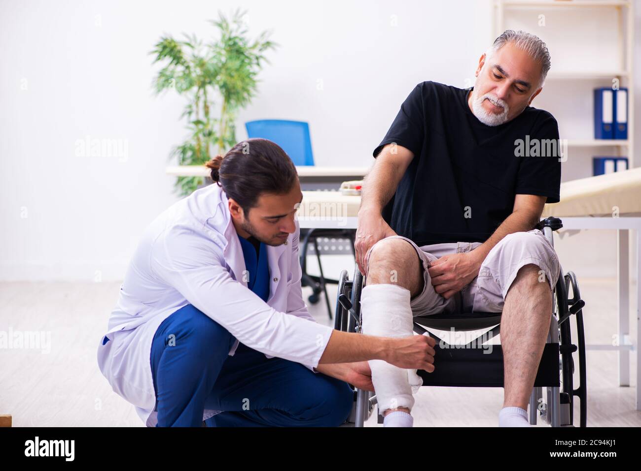 Old injured man visiting young doctor traumatologist Stock Photo - Alamy