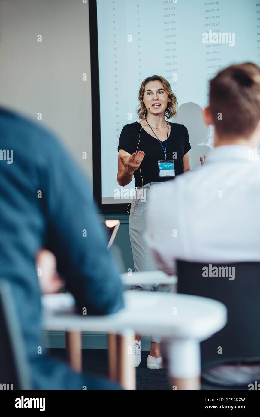 Businesswoman giving a speech in modern conference room. Manager giving ...