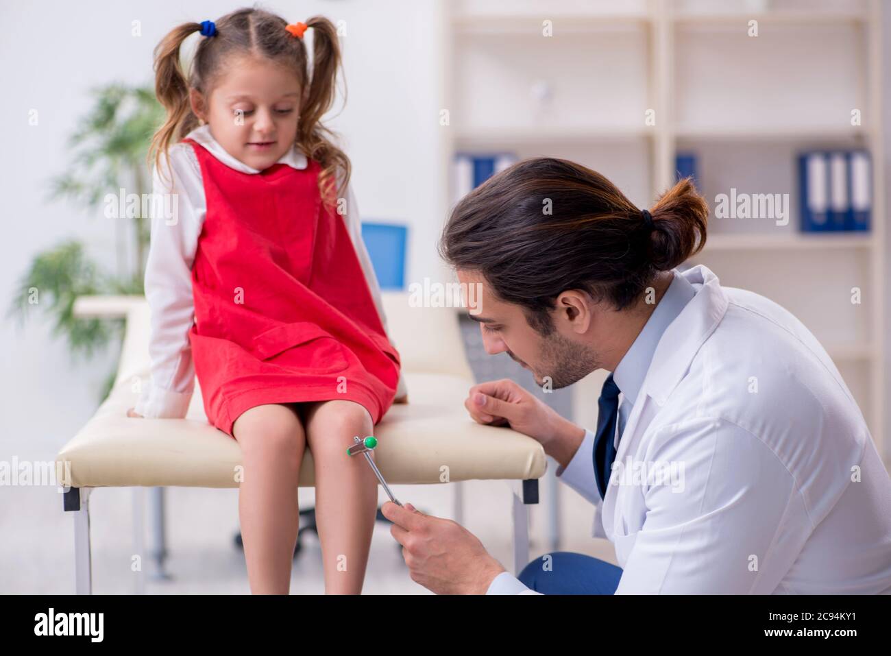Small girl visiting young doctor Stock Photo - Alamy