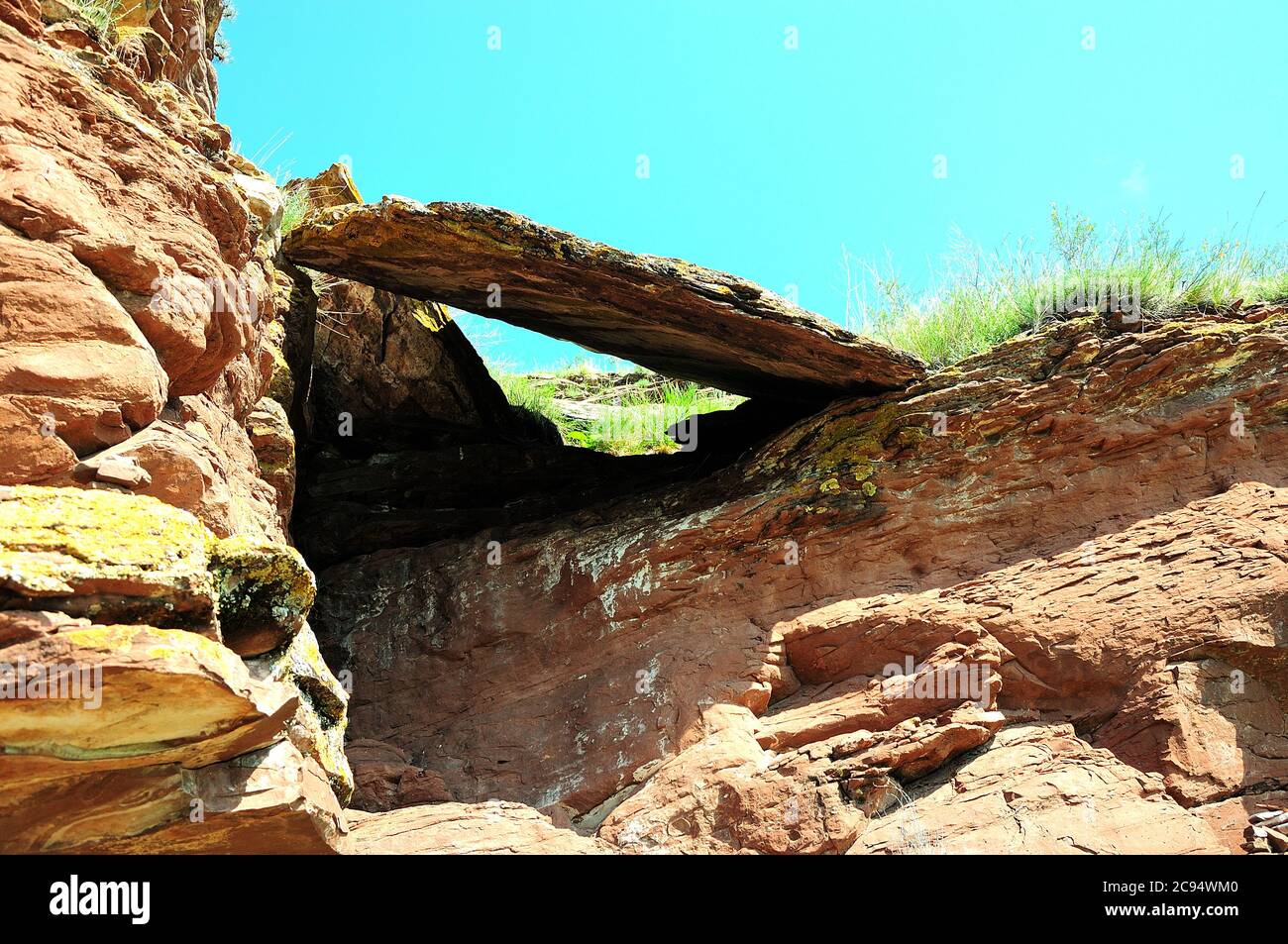 A natural stone slab lies on top of a hill forming an arch. Mountain ...
